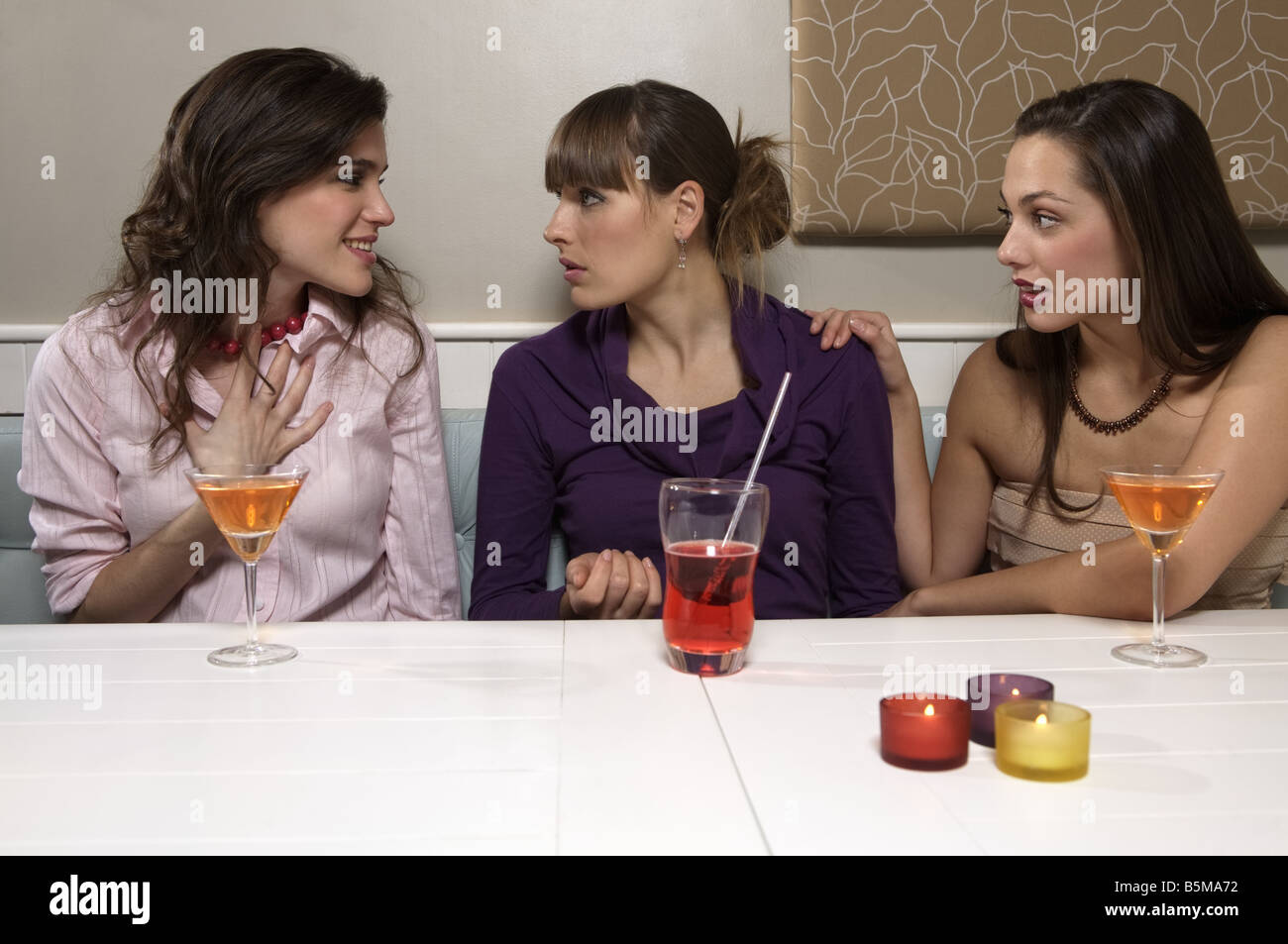 Three women talking over drinks Stock Photo - Alamy
