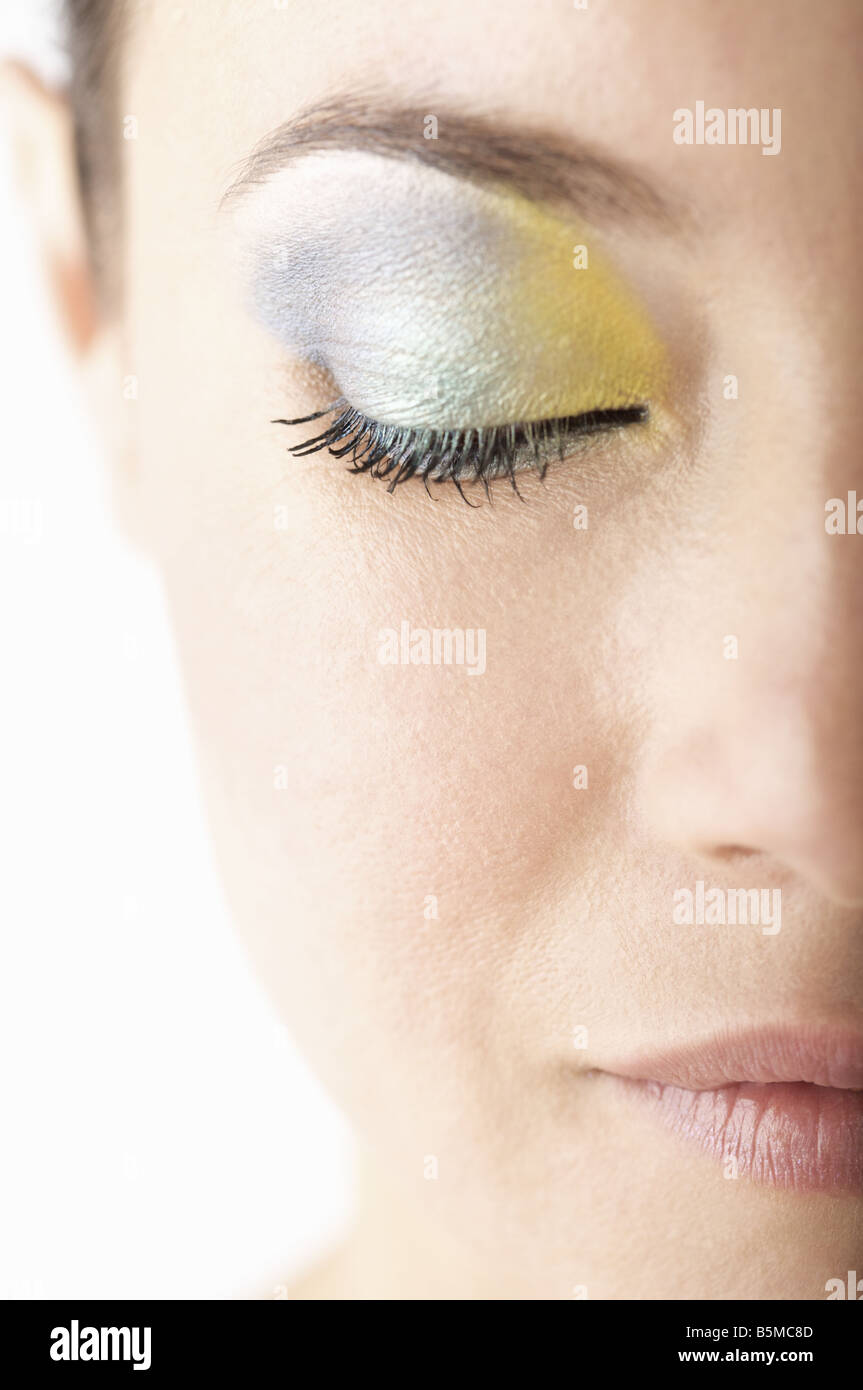 A woman wearing blue and yellow eyeshadow Stock Photo - Alamy