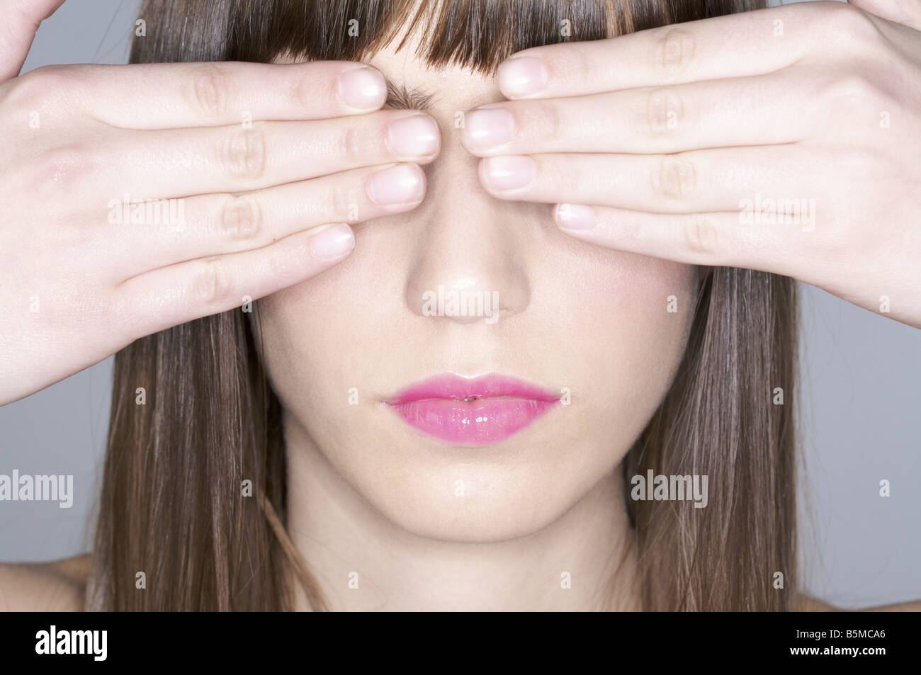 A woman covering her eyes Stock Photo - Alamy