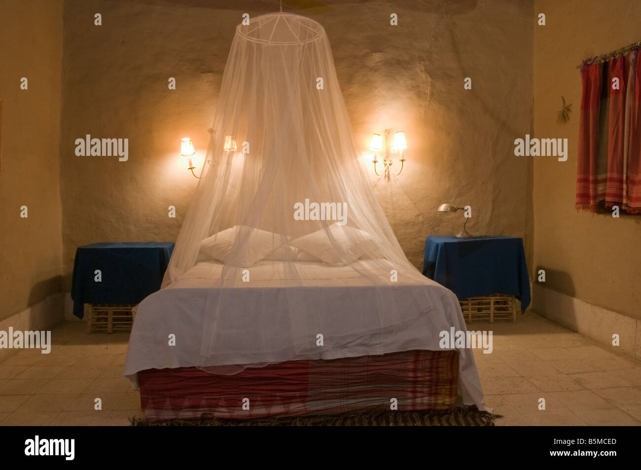 A bedroom with a draped mosquito net of Nour El Gourna hotel in Luxor ...