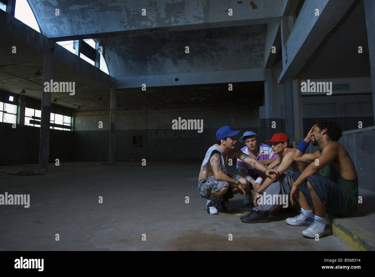 Four young men sitting and talking Stock Photo - Alamy