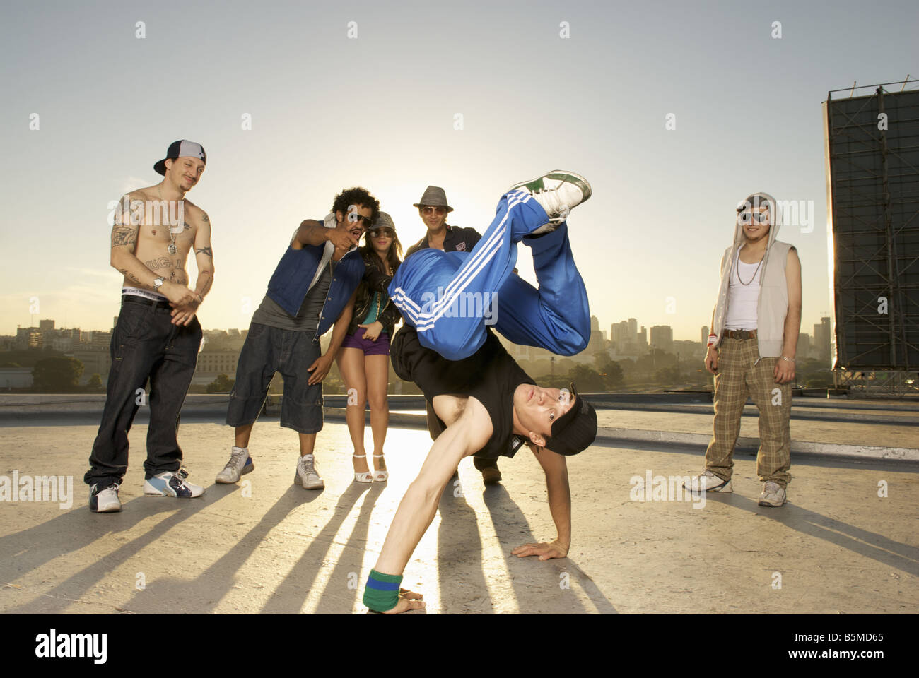 A group of young men and a teenage girl break dancing on a roof Stock ...