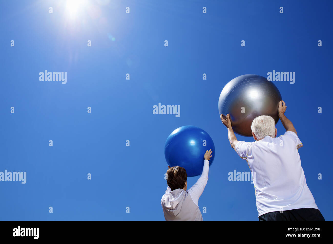 An elderly couple holding exercise balls Stock Photo - Alamy