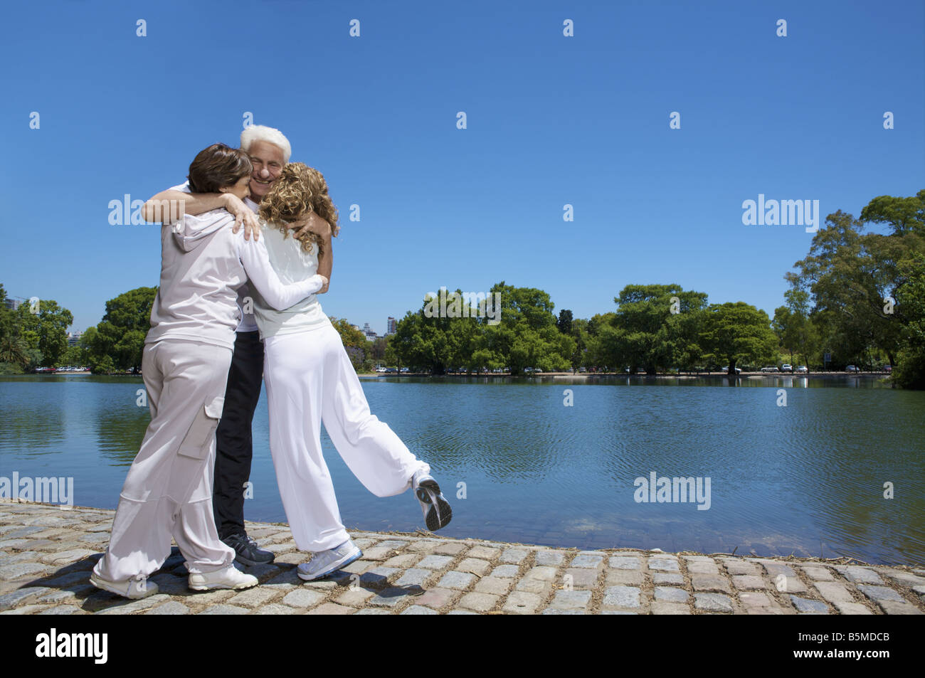 Three people hugging Stock Photo - Alamy