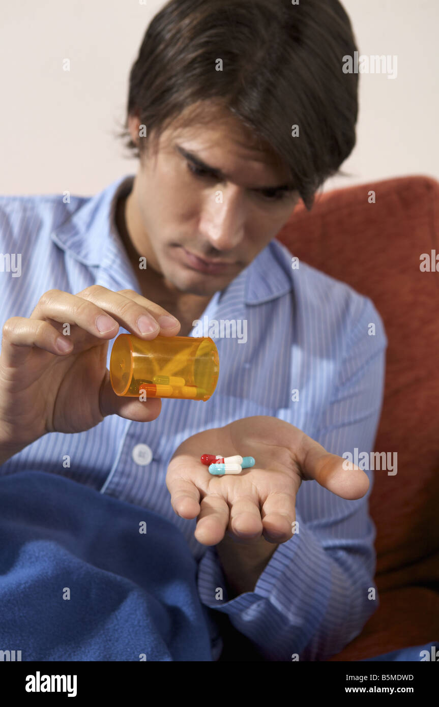 A man dropping pills into his hand Stock Photo - Alamy