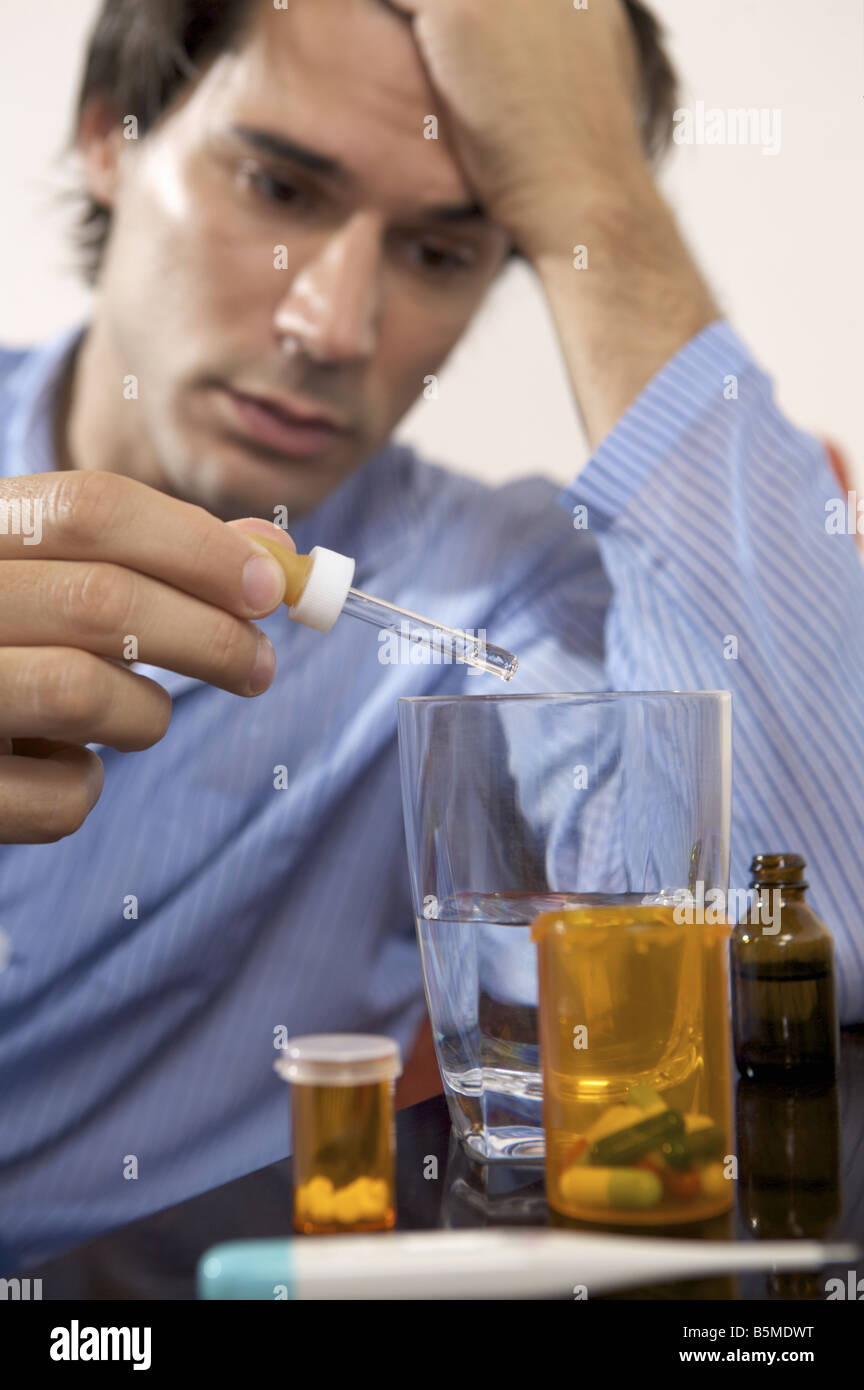 A man putting drops into a glass Stock Photo - Alamy