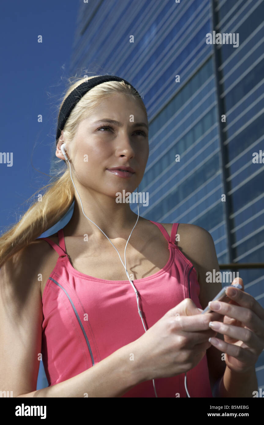 A young woman listening to an MP3 player Stock Photo - Alamy