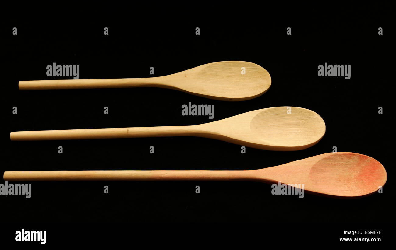 Three wooden spoons lined up on a table Stock Photo - Alamy