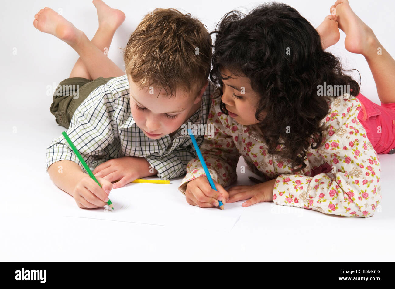 Two friends are drawing together lying on the floor Stock Photo - Alamy