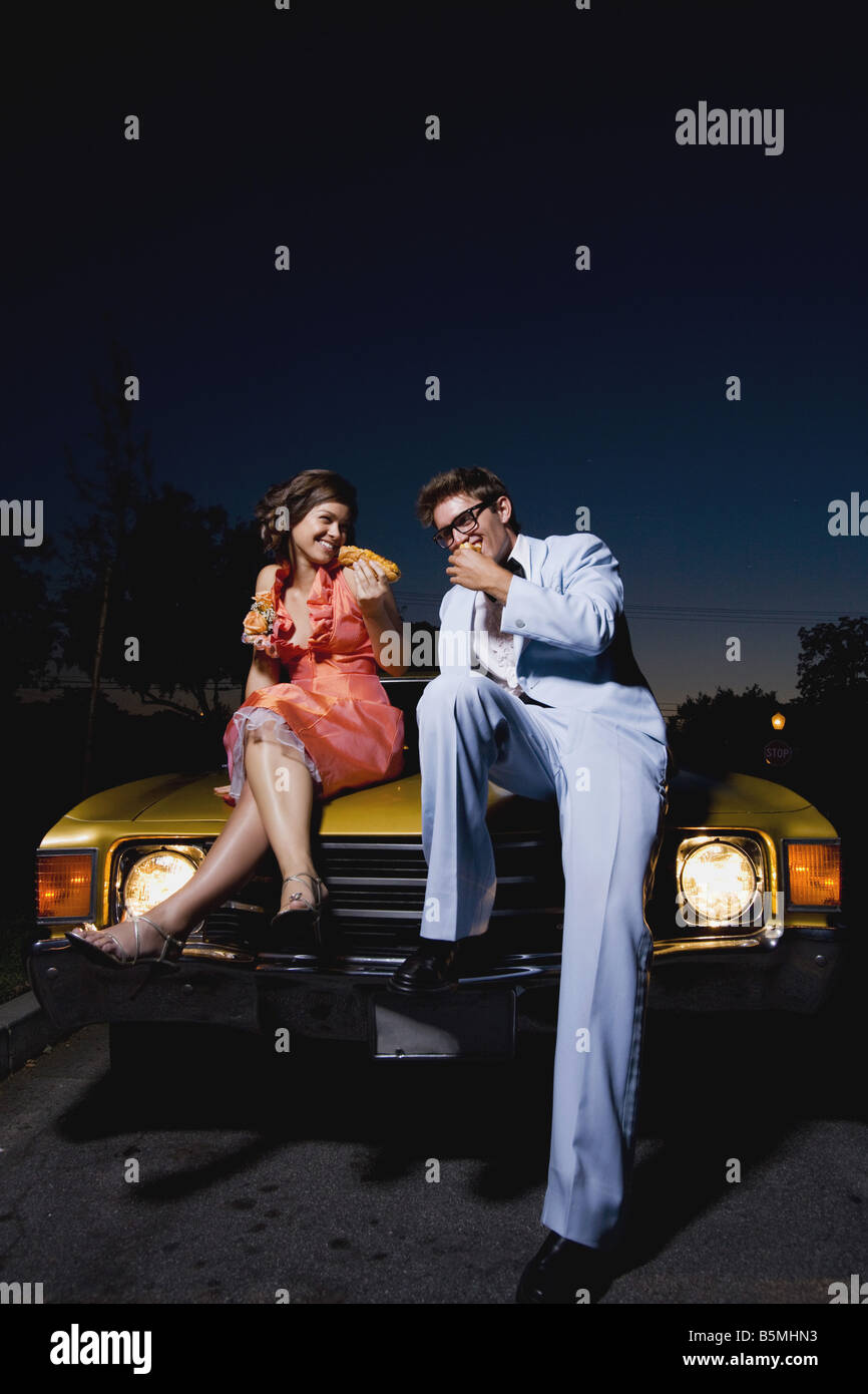 Prom goers sitting on car eating hot dogs Stock Photo - Alamy