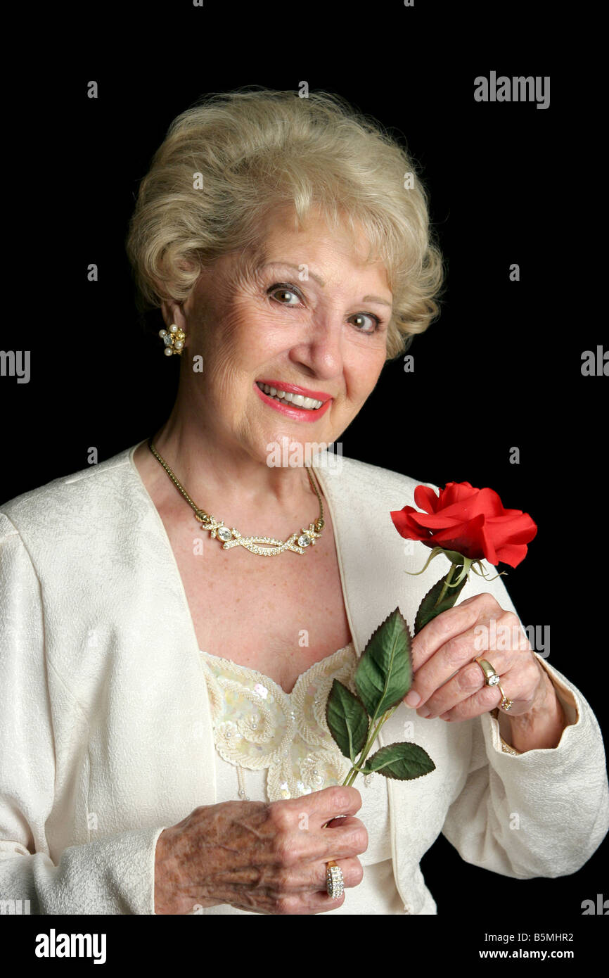 A beautiful successful senior lady dressed in formalwear holding a red ...