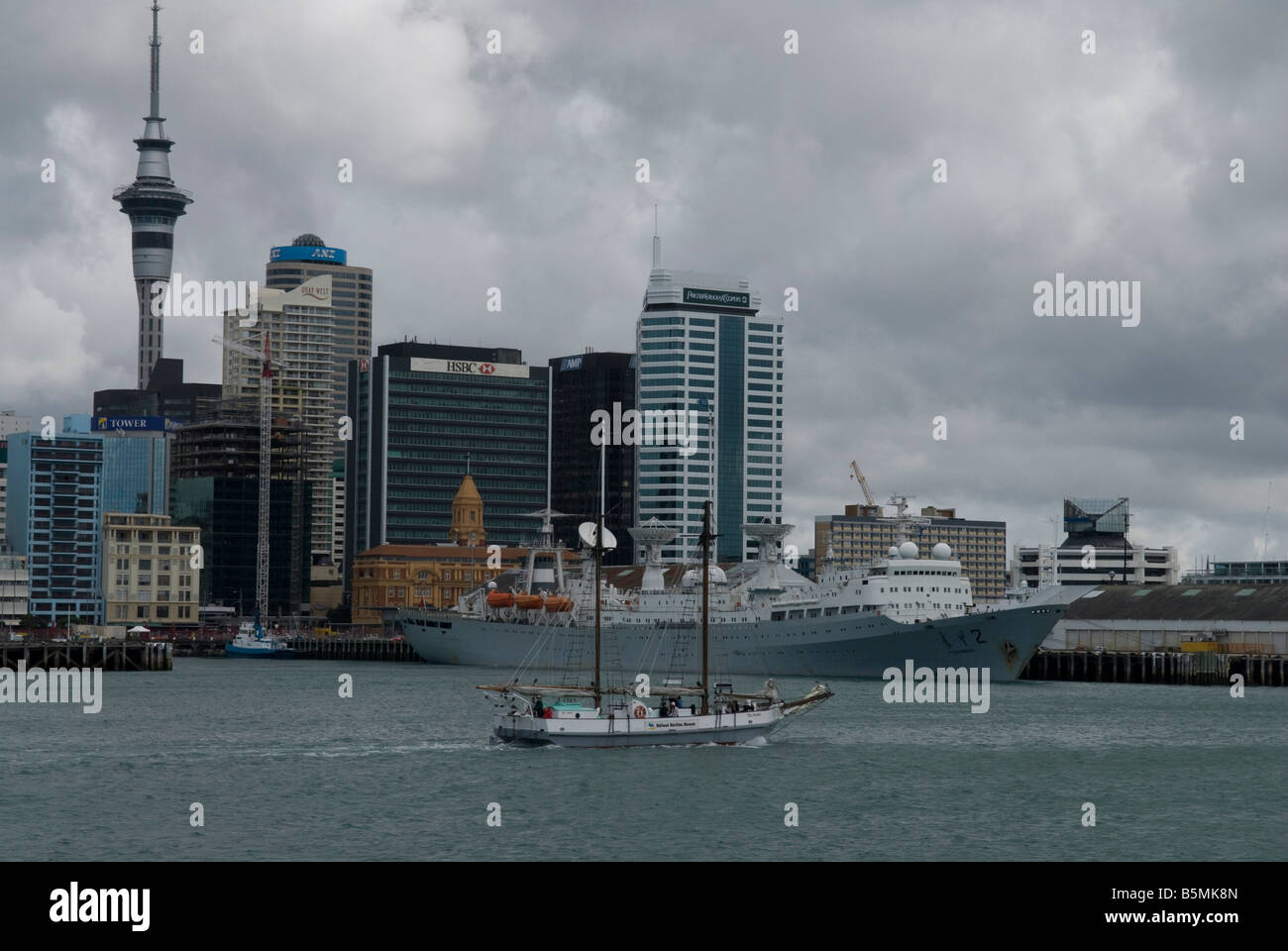 Small boat entering Auckland harbour with the city skyline in the ...