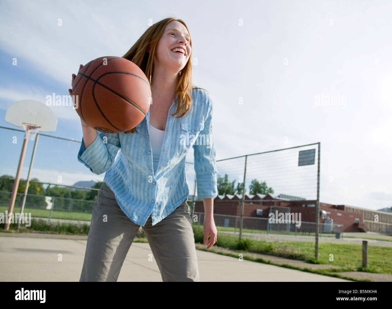 smiling woman playing basketball outdoors Stock Photo - Alamy