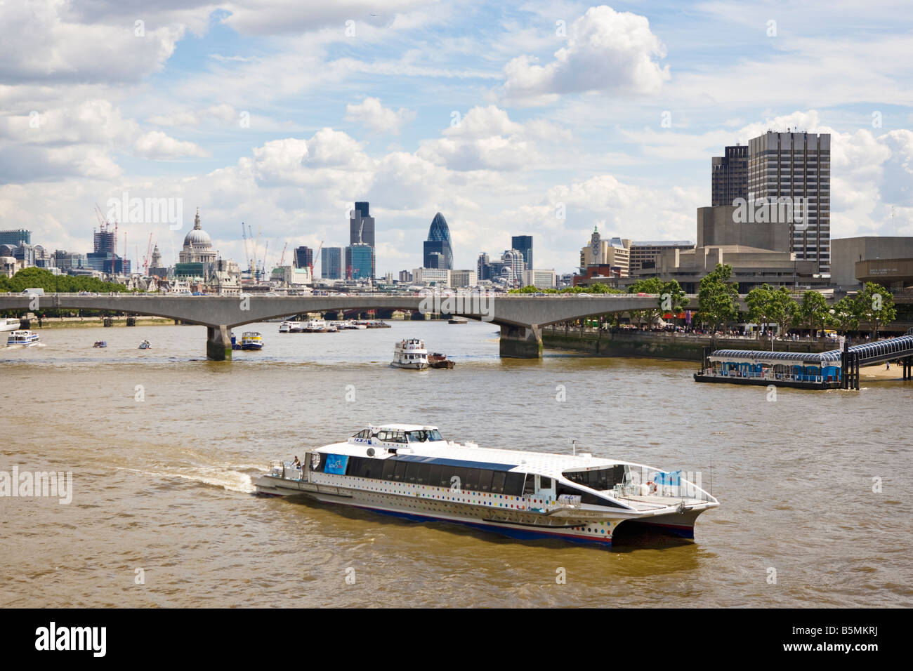 Boats sailing down The River Thames with Waterloo Bridge and the London ...