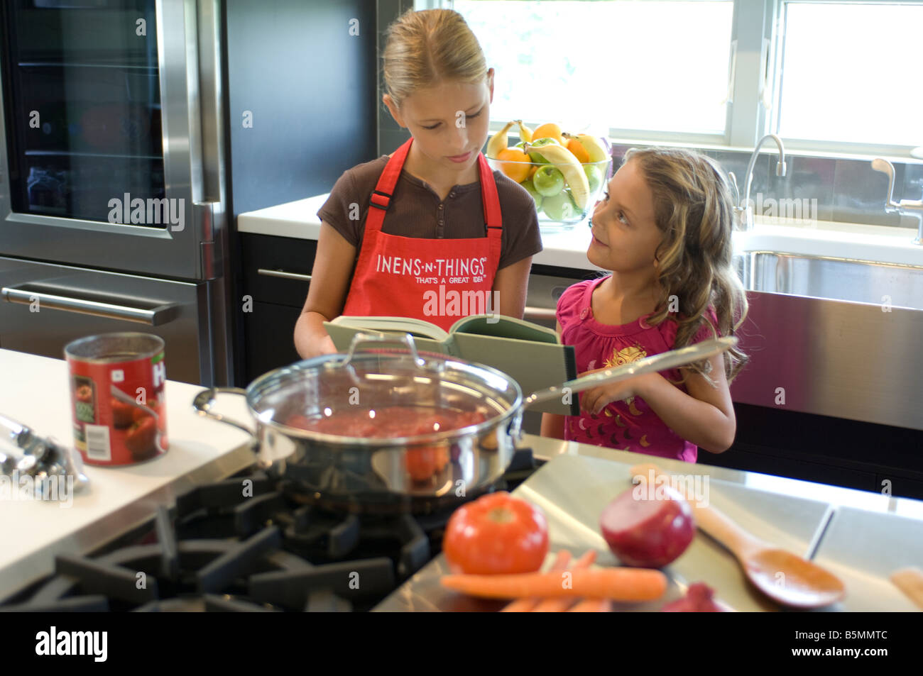 Two young sisters cooking together Stock Photo - Alamy
