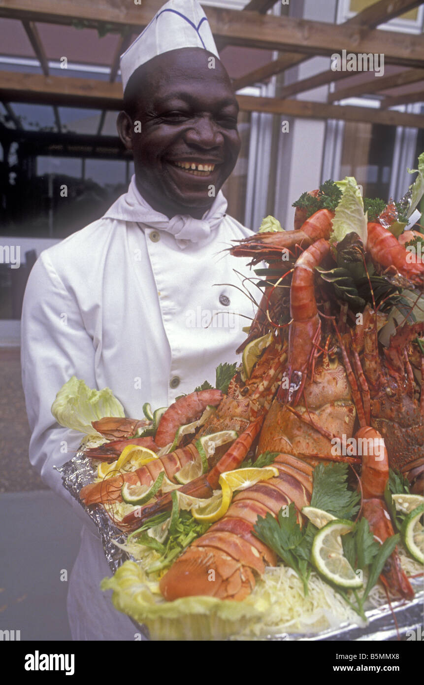 Happy African Cook or Chef carrying huge presentation platter of ...