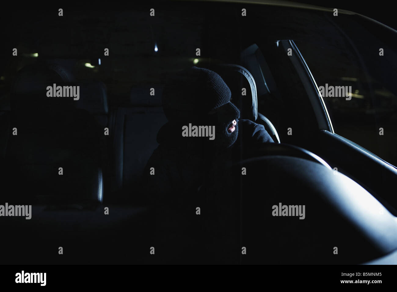 Front profile of masked thief in car Stock Photo - Alamy