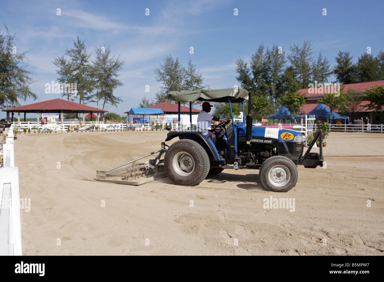 A tractor smoothing the ground for horse show jumping competition Stock ...