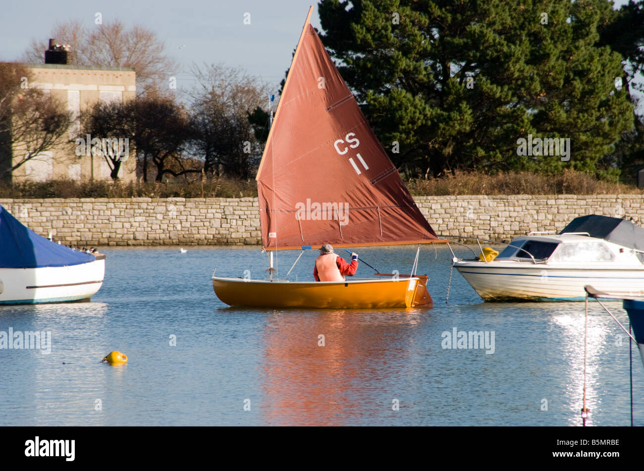 Small wooden dingy sailing across frame Stock Photo - Alamy