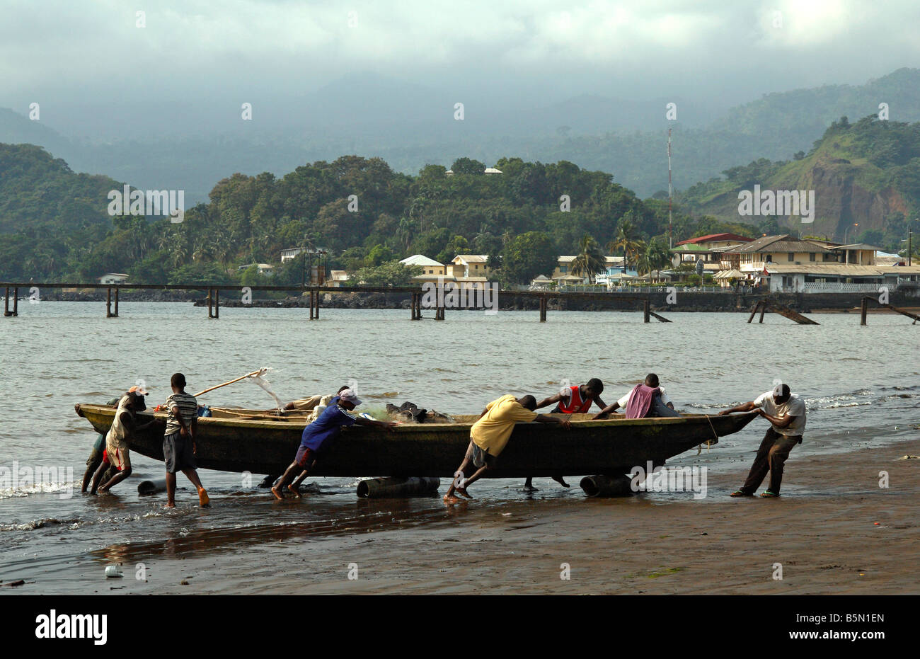 Fishermen dragging boat in at Limbé Cameroon West Africa Mount Cameroon ...