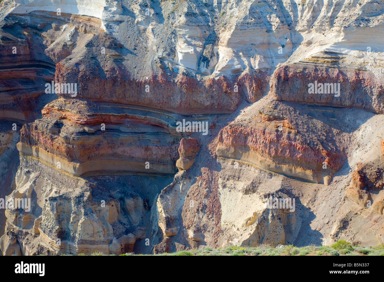 White layer of pumice atop older volcanic tuff layers in the cliff of ...