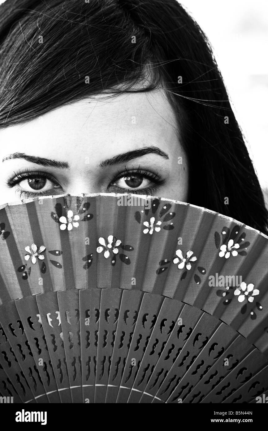 Spanish woman behind traditional fan Stock Photo - Alamy
