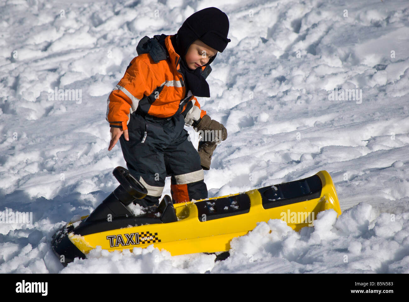 A young boy and his yellow sled Stock Photo - Alamy