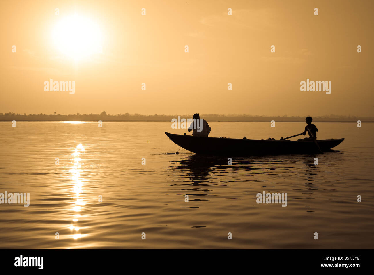 Man and boy in boat on the Ganges River, Varanasi, India Stock Photo ...