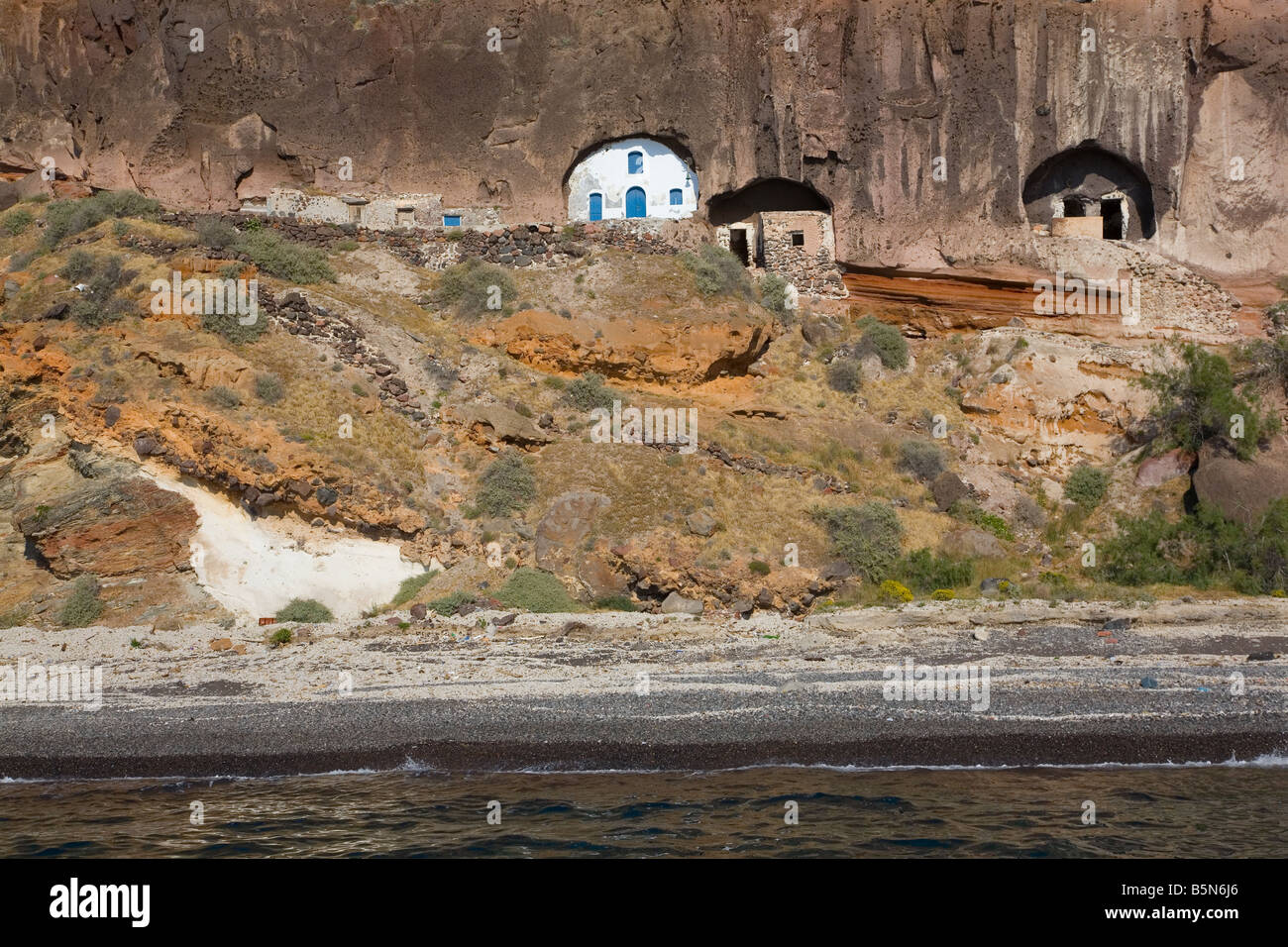 Cave churches carved into soft volcanic rock in the caldera cliff of ...