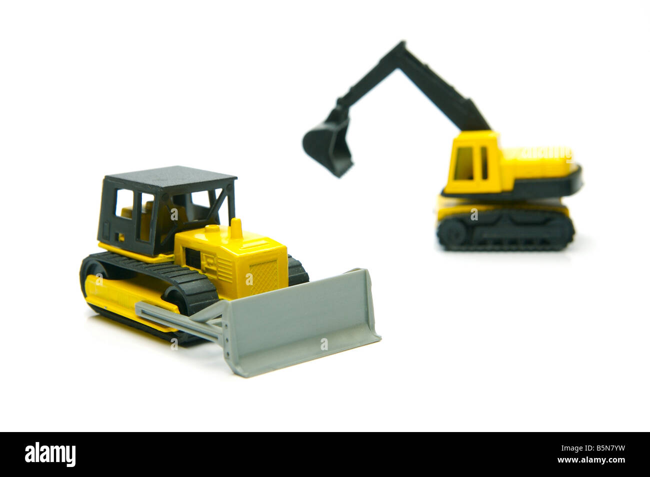 Miniature model earth moving equipment isolated against a white ...