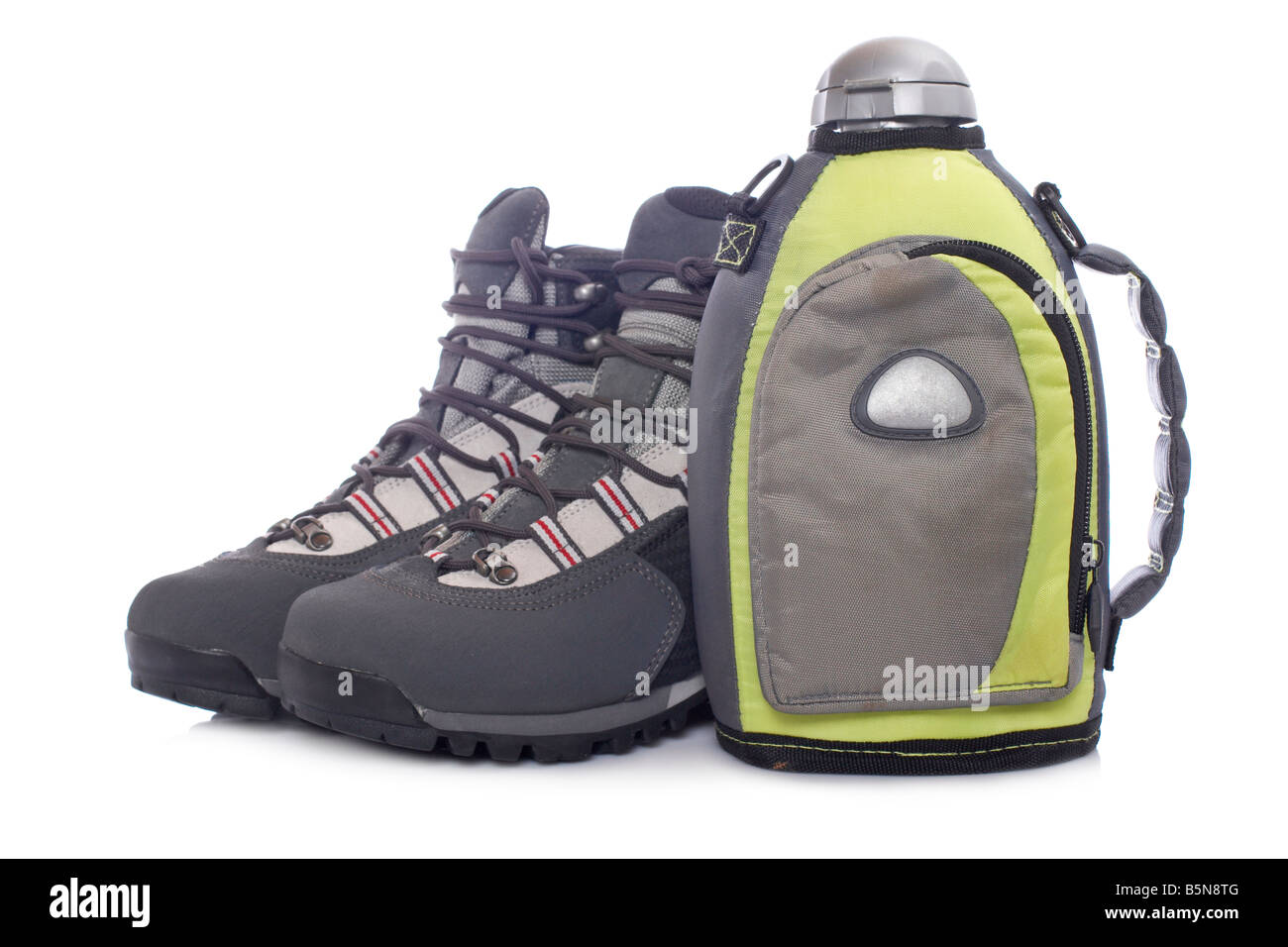 A pair of hiking boots and canteen with shadow reflected on white ...