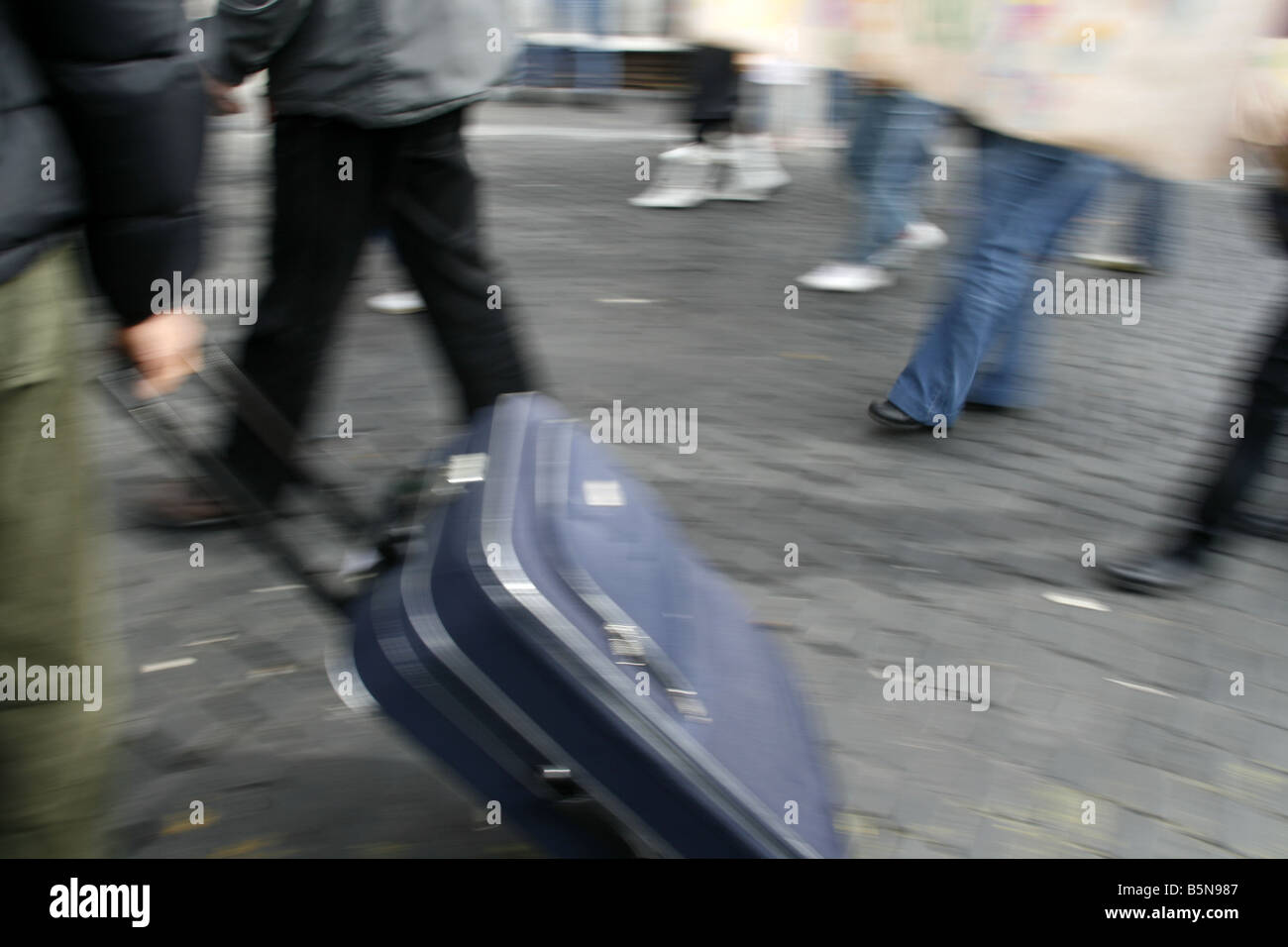 young man pulling trolley luggage case in town Stock Photo - Alamy