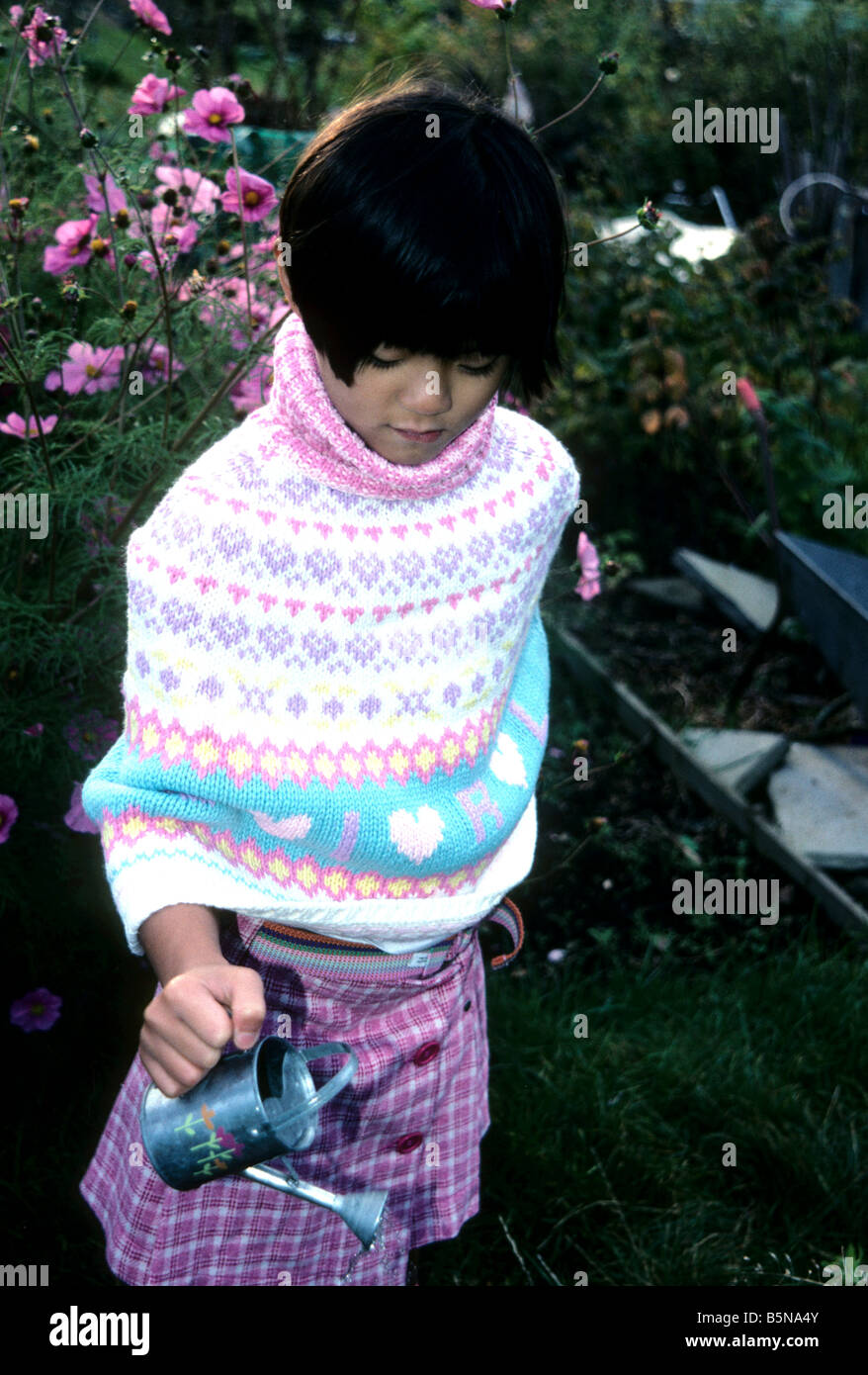 Pretty little Chinese girl in an English garden Stock Photo - Alamy
