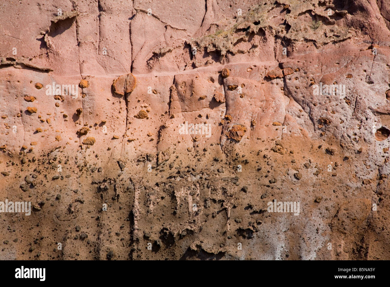 Red volcanic tuff layers in the caldera cliffs of Santorini island ...
