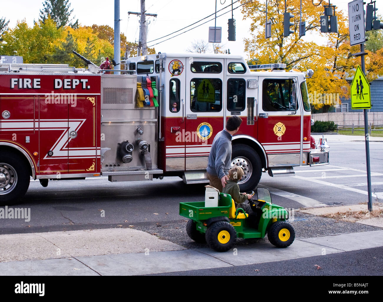 Father and son look at fire engine in small town, USA, on a fall day ...