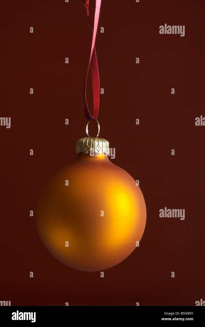 Burnt Orange Christmas bauble on deep red background Stock Photo - Alamy