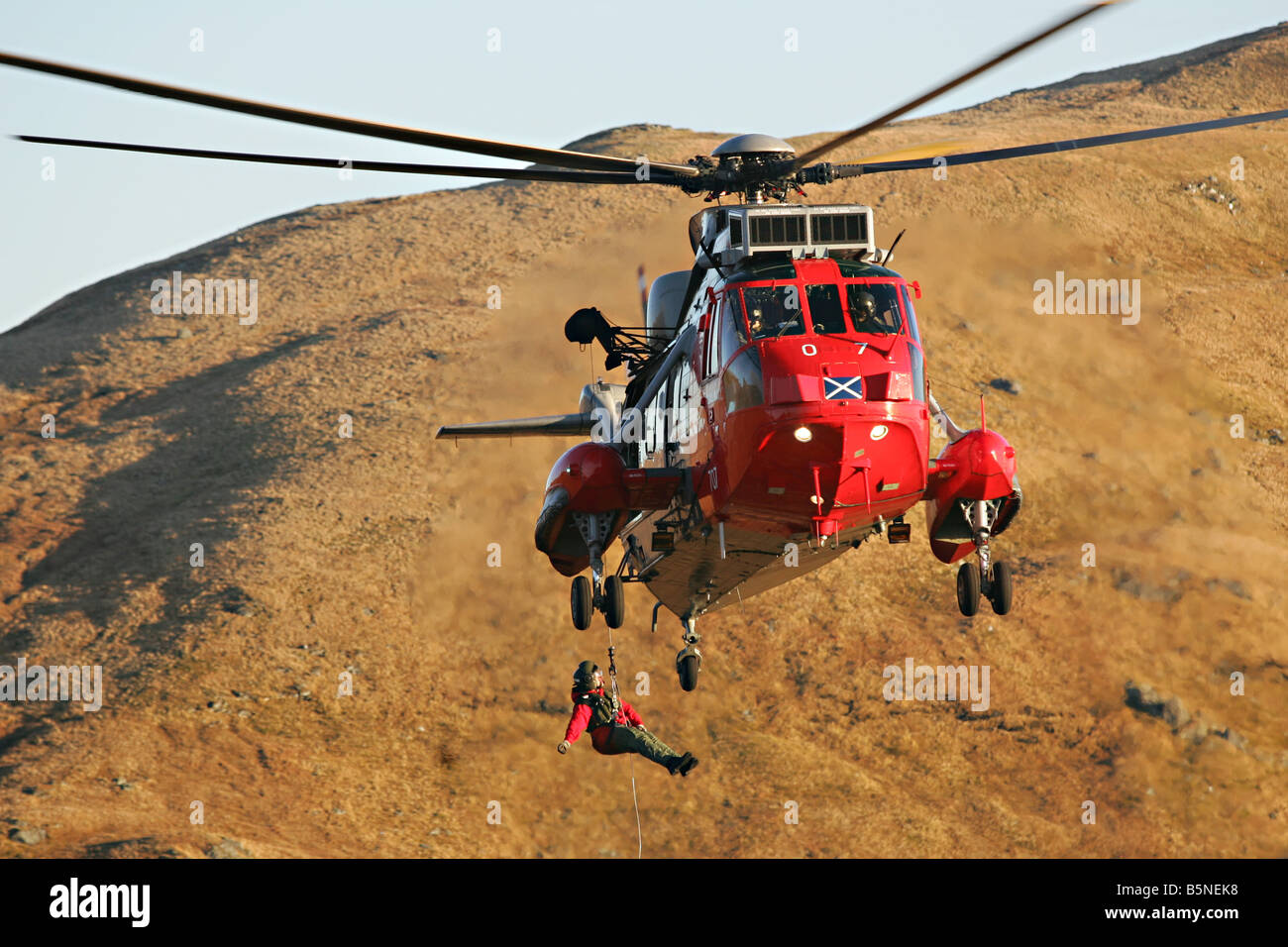 A Royal Navy search and rescue Sea King helicopter winches a crew ...