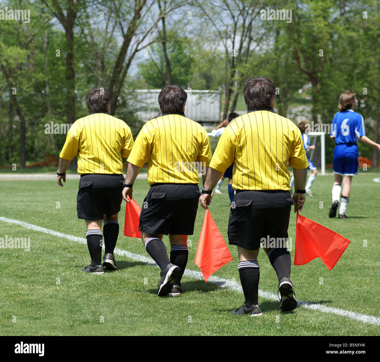 Triplet soccer side referee with red flag. Composition with three ...