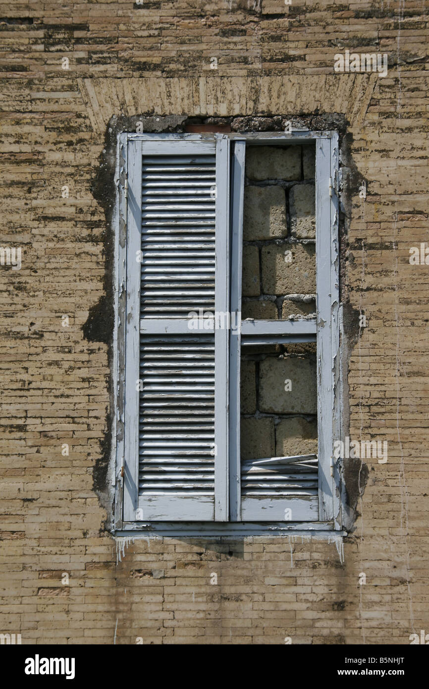 one damaged window shutters in derelict property Stock Photo - Alamy