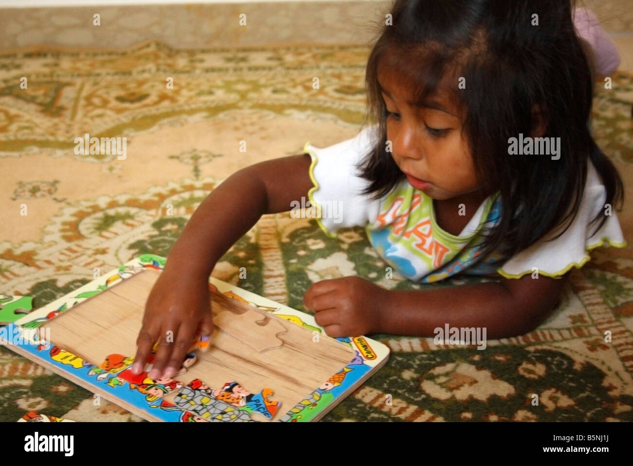 Kid plays with jigsaw puzzle Stock Photo - Alamy
