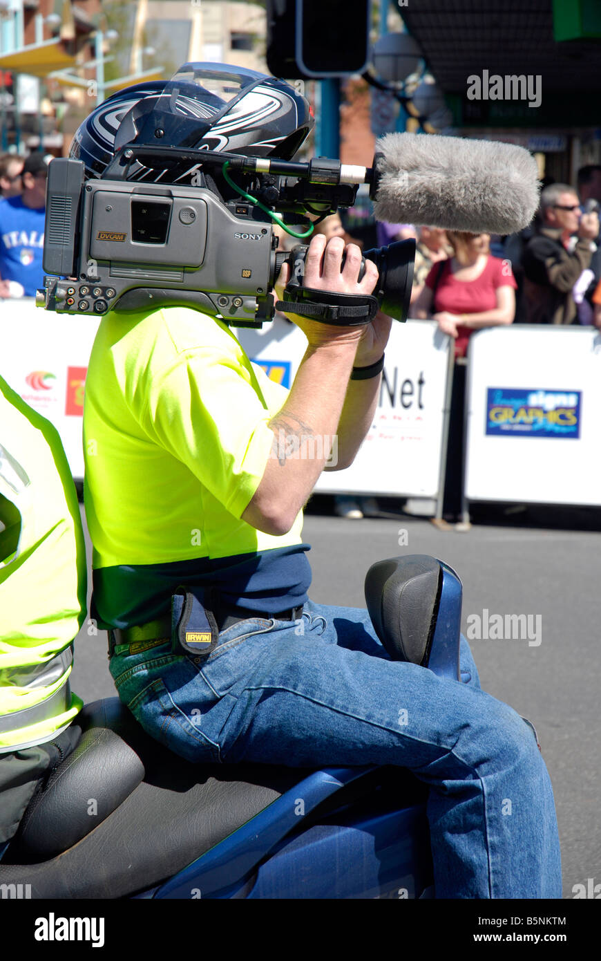A television cameraman covering a sporting event as a pillion passenger ...