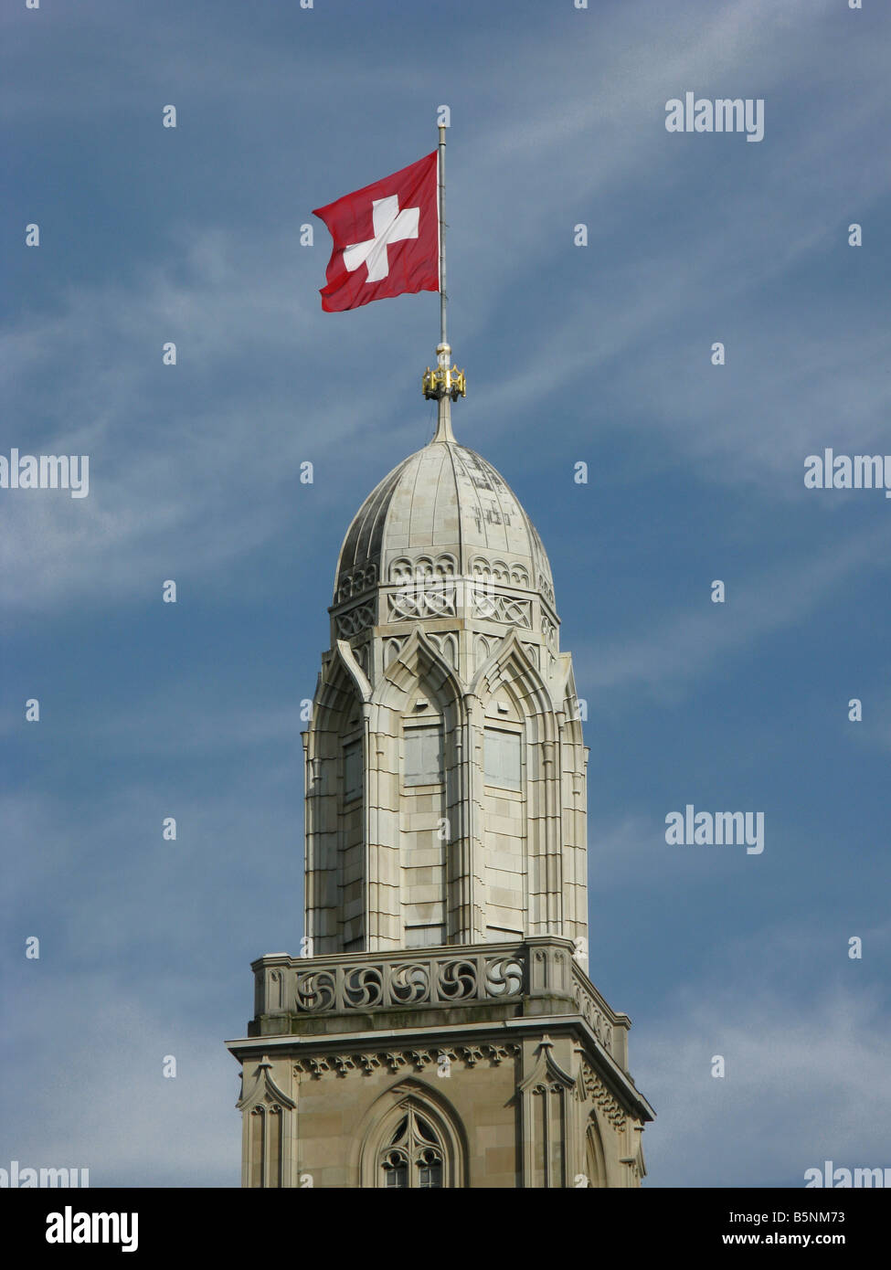 Swiss national flag on top of the church spire of the Zurich ...