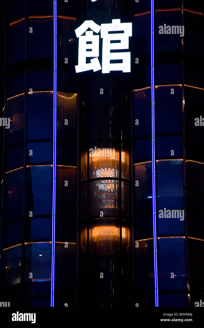 Neon lights and an glass elevator on a skyscraper in the Nishi Shinjuku ...