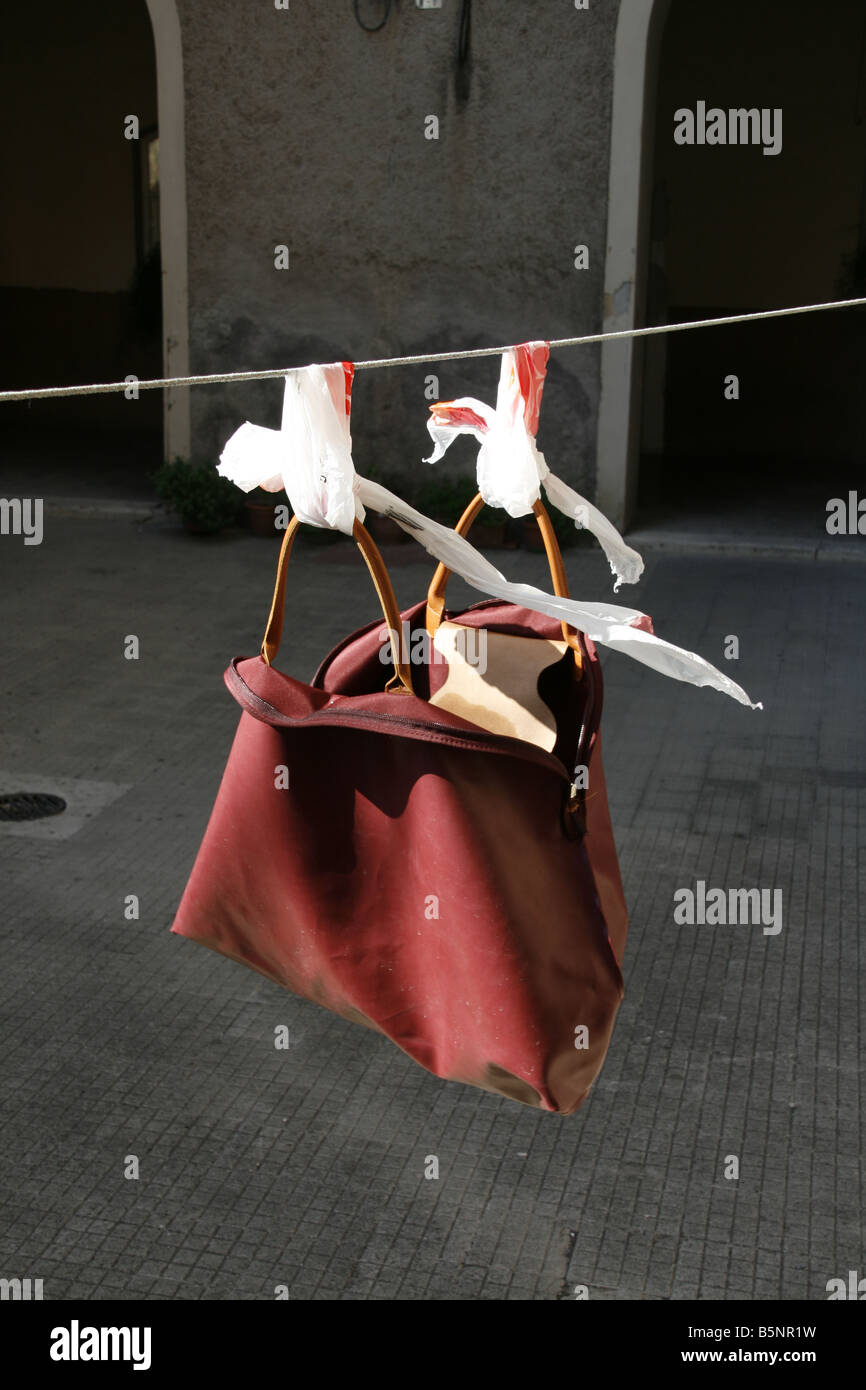 old woman's bag used as a peg container holder on clothes line in italy ...