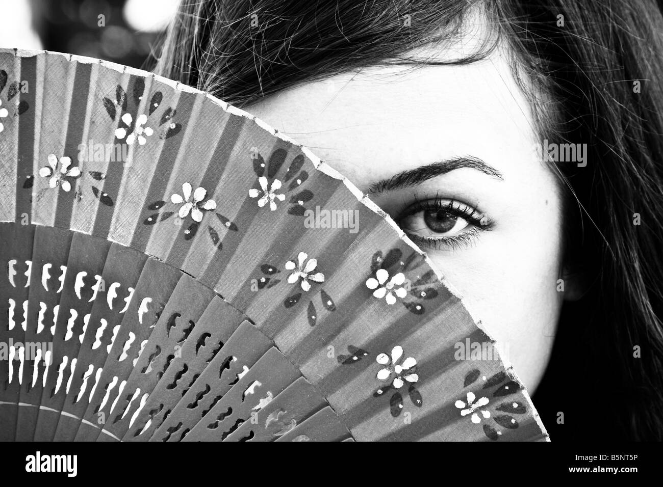 Spanish woman behind traditional fan Stock Photo - Alamy
