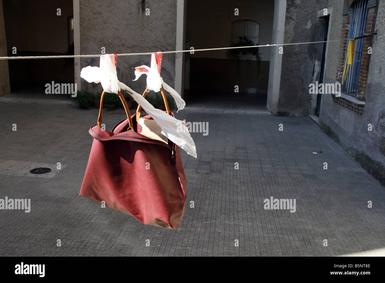 old woman's bag used as a peg container holder on clothes line in italy ...