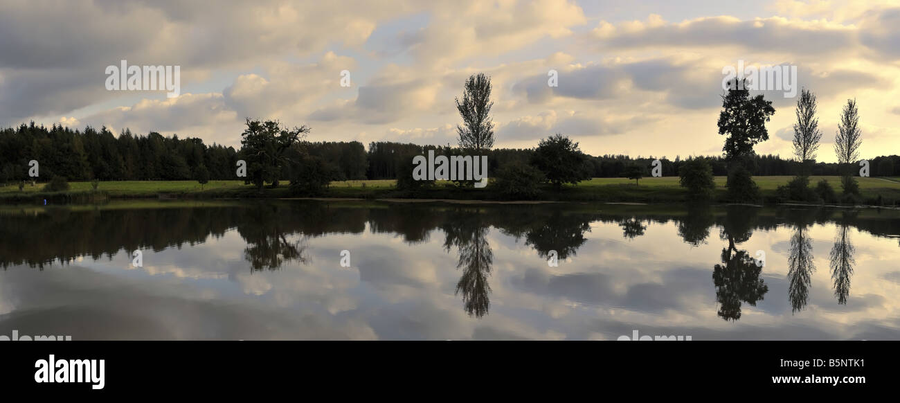 cumulo nimbus clouds at sunset reflected in a lake Stock Photo - Alamy