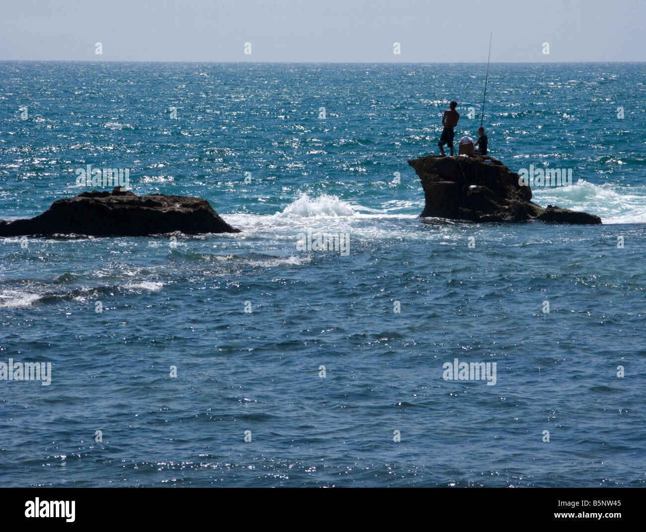 YOUNG MEN FISHING ON ROCKS OLD CITY ACCO ISRAEL Stock Photo - Alamy