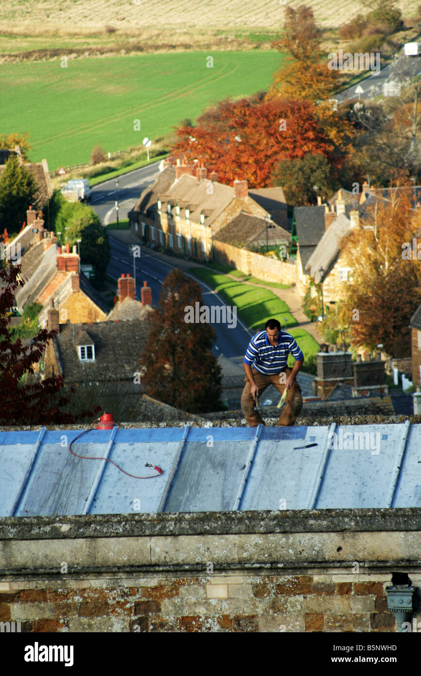 A man working on a church roof replacing lead Stock Photo - Alamy