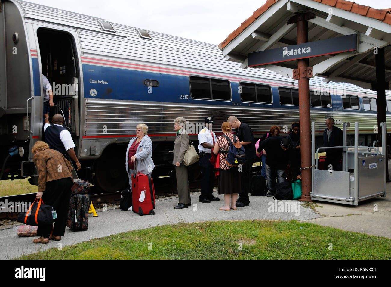 Amtrak railroad conductors assisting passengers from train America ...